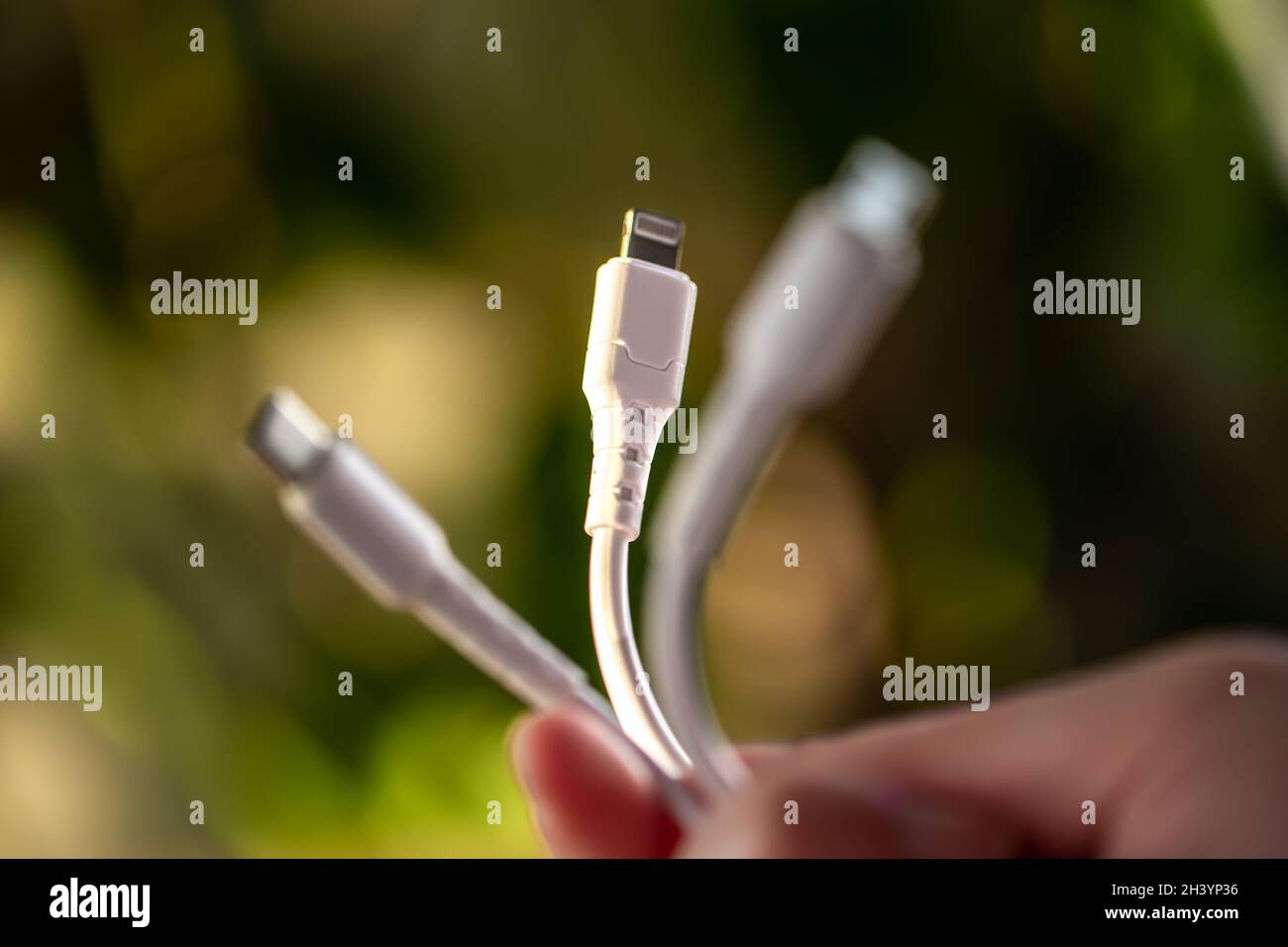 Three different connectors for charging a mobile phone on a blurred ...