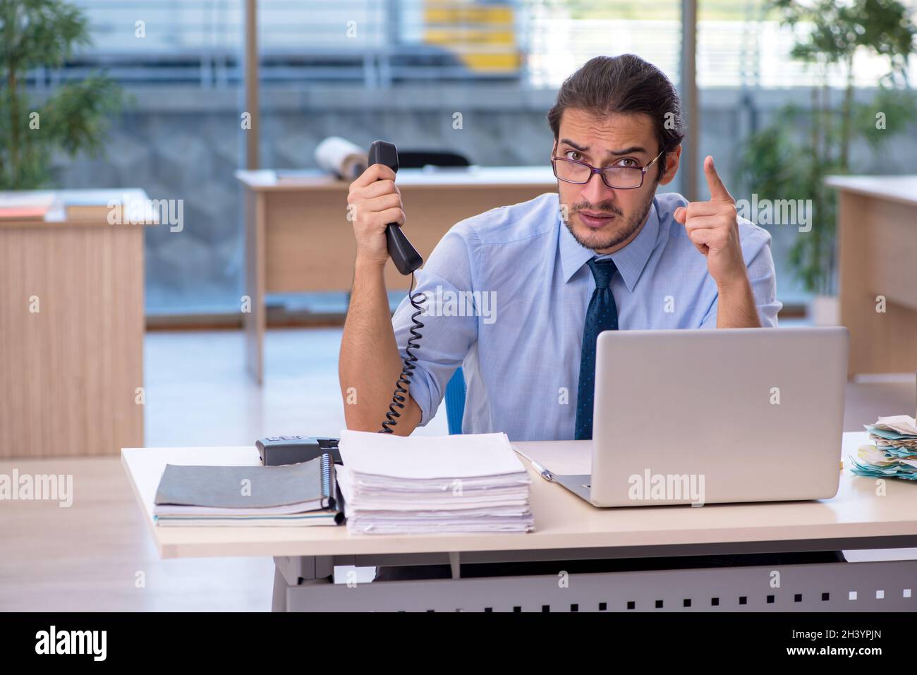 Young male accountant working in the office Stock Photo - Alamy