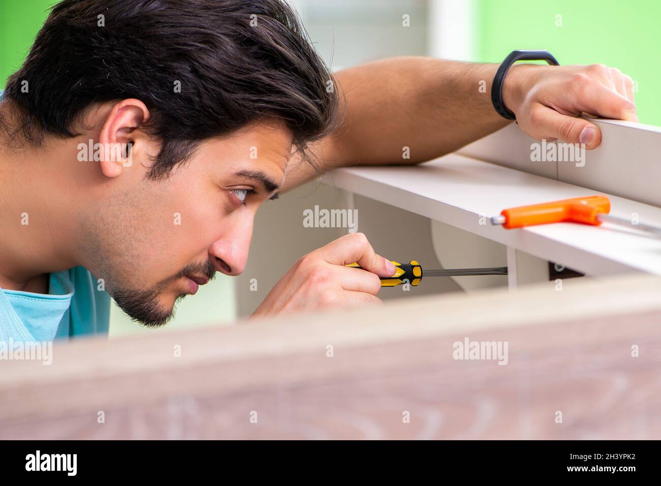 Man repairing furniture at home Stock Photo - Alamy