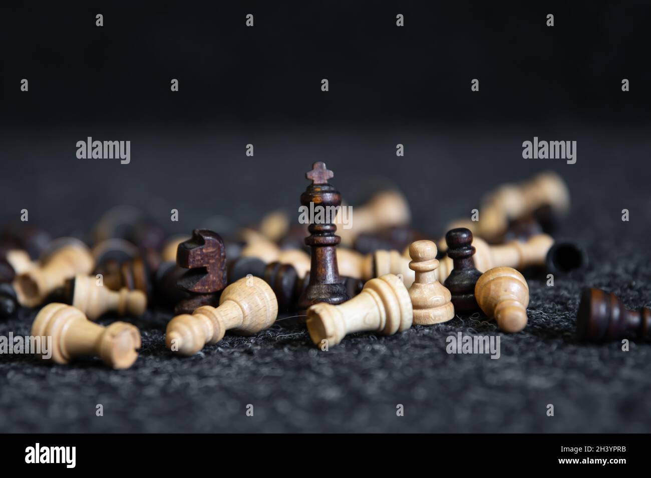 Scattered chess pieces on a blurred black background Stock Photo - Alamy