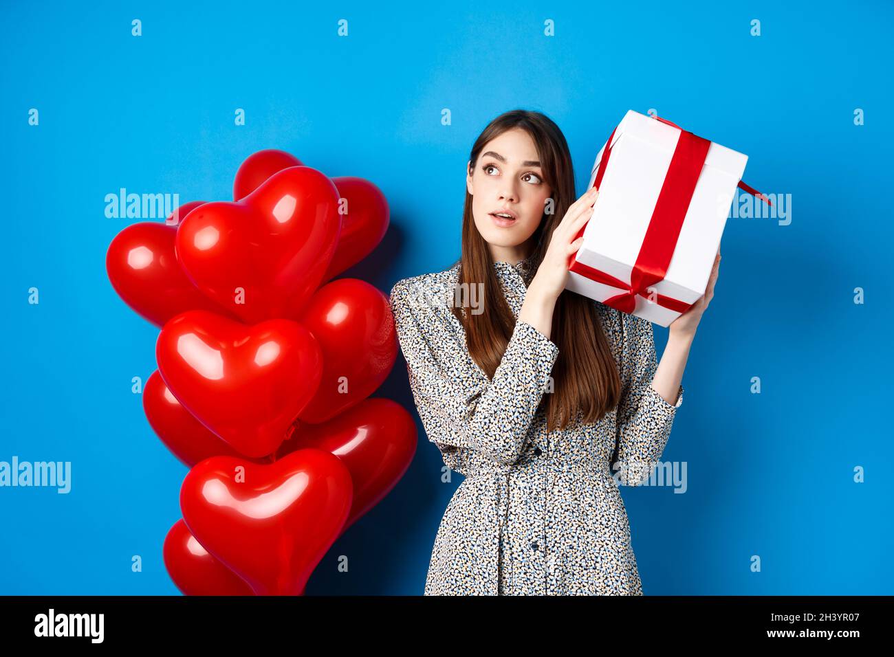 Woman shaking gift box hi-res stock photography and images - Alamy