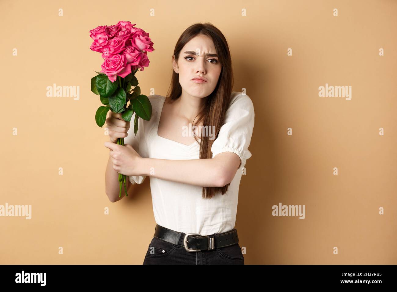 Happy valentines day. Angry girl hitting someone with flowers, swinging ...