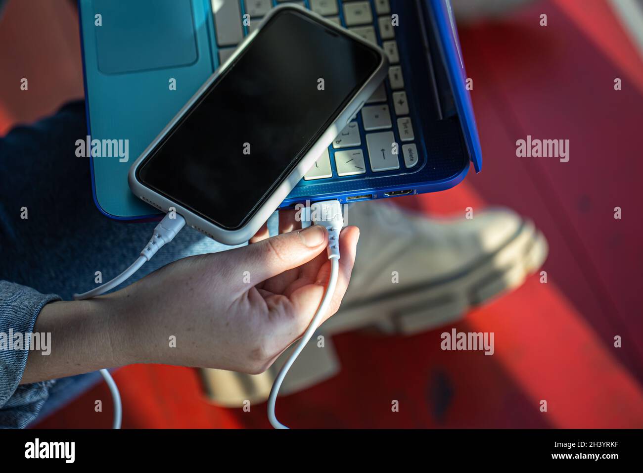 The smartphone is connected to the laptop via USB cable Stock Photo - Alamy