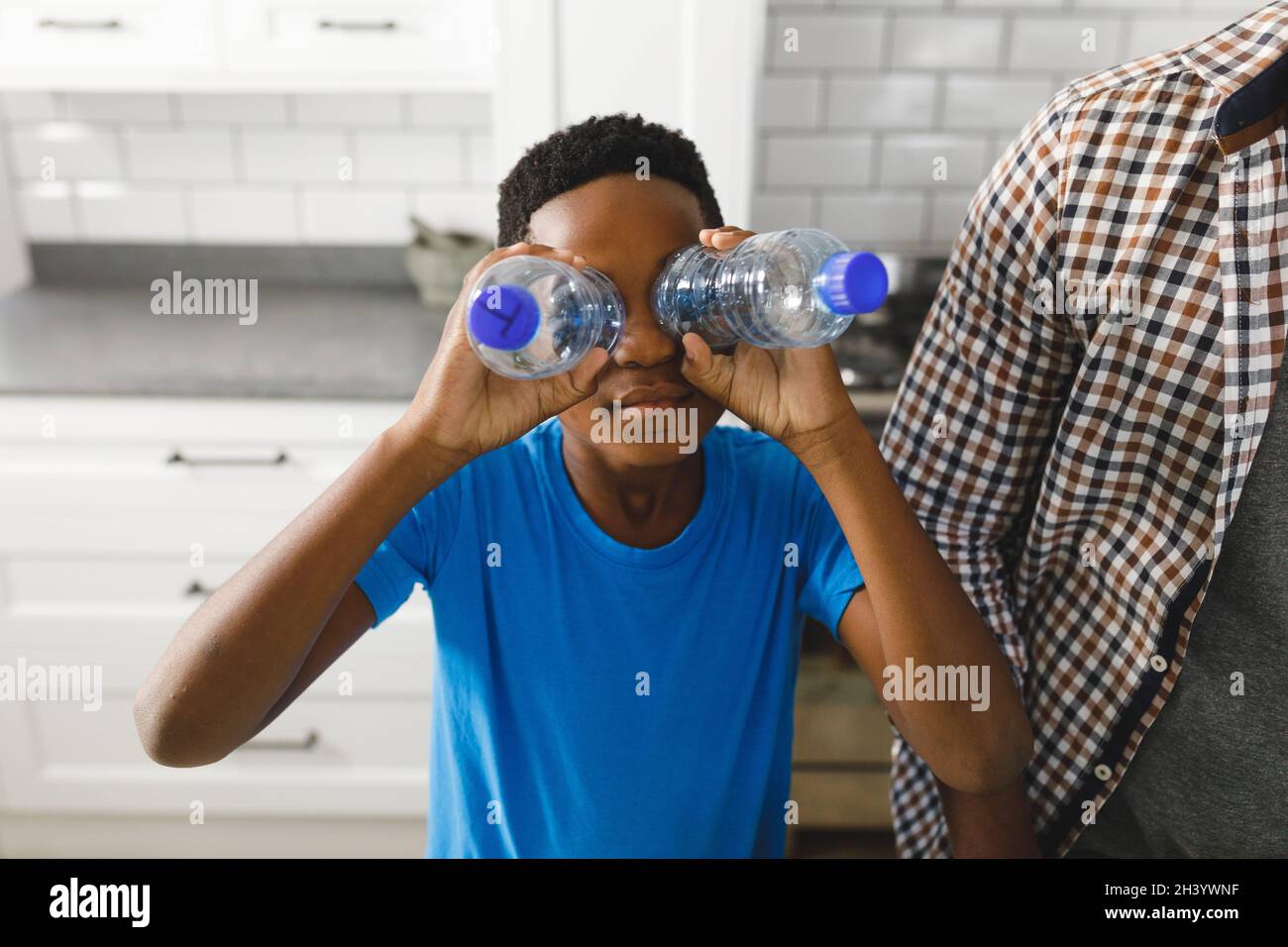 Happy african american son sorting recycling with father in kitchen ...