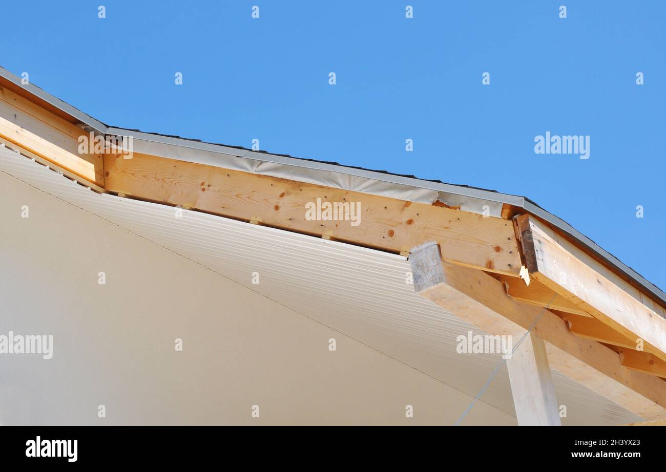 Close up on house roofing construction with installing soffits and ...