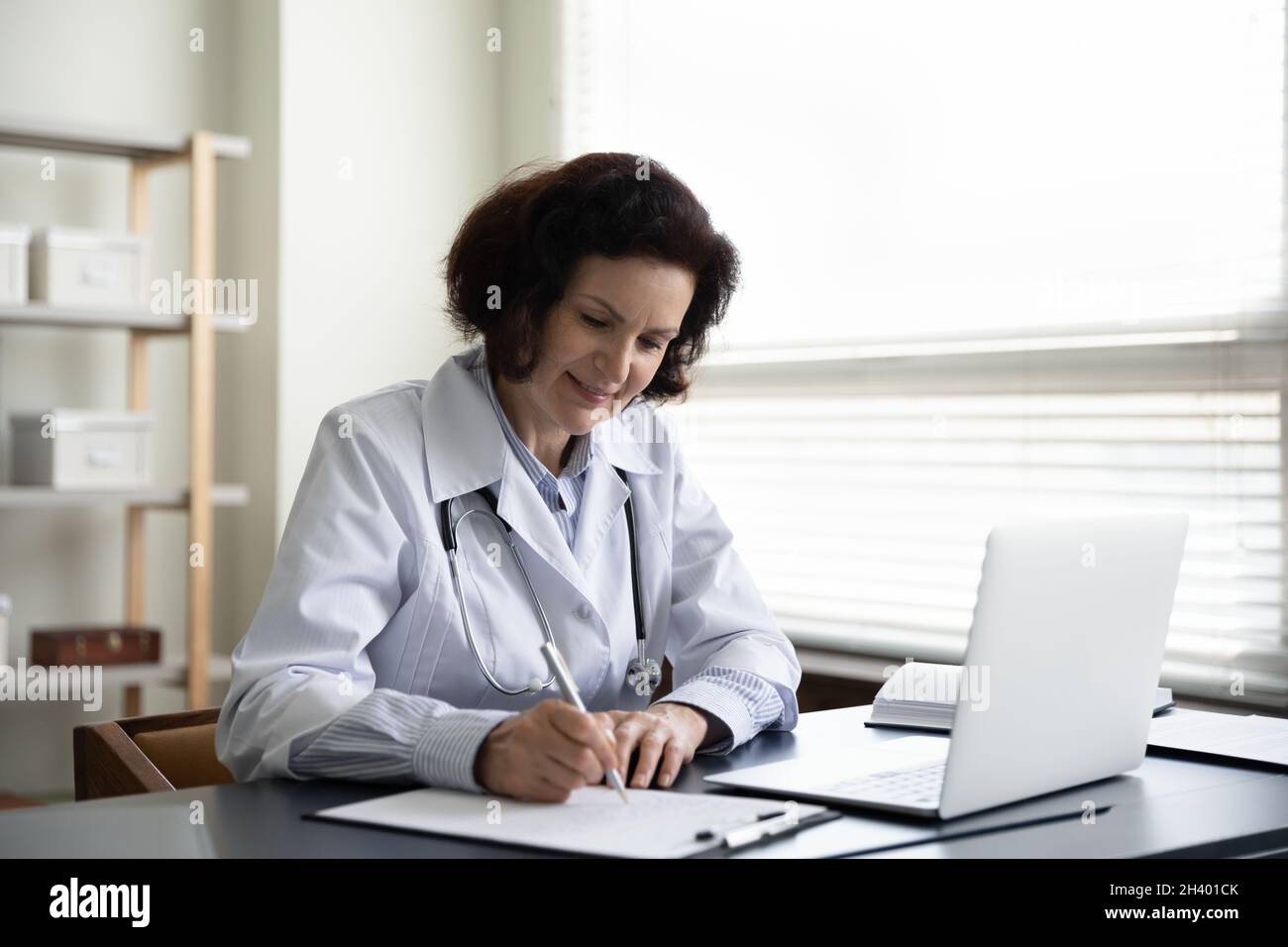 Doctor writing prescription on table hi-res stock photography and ...