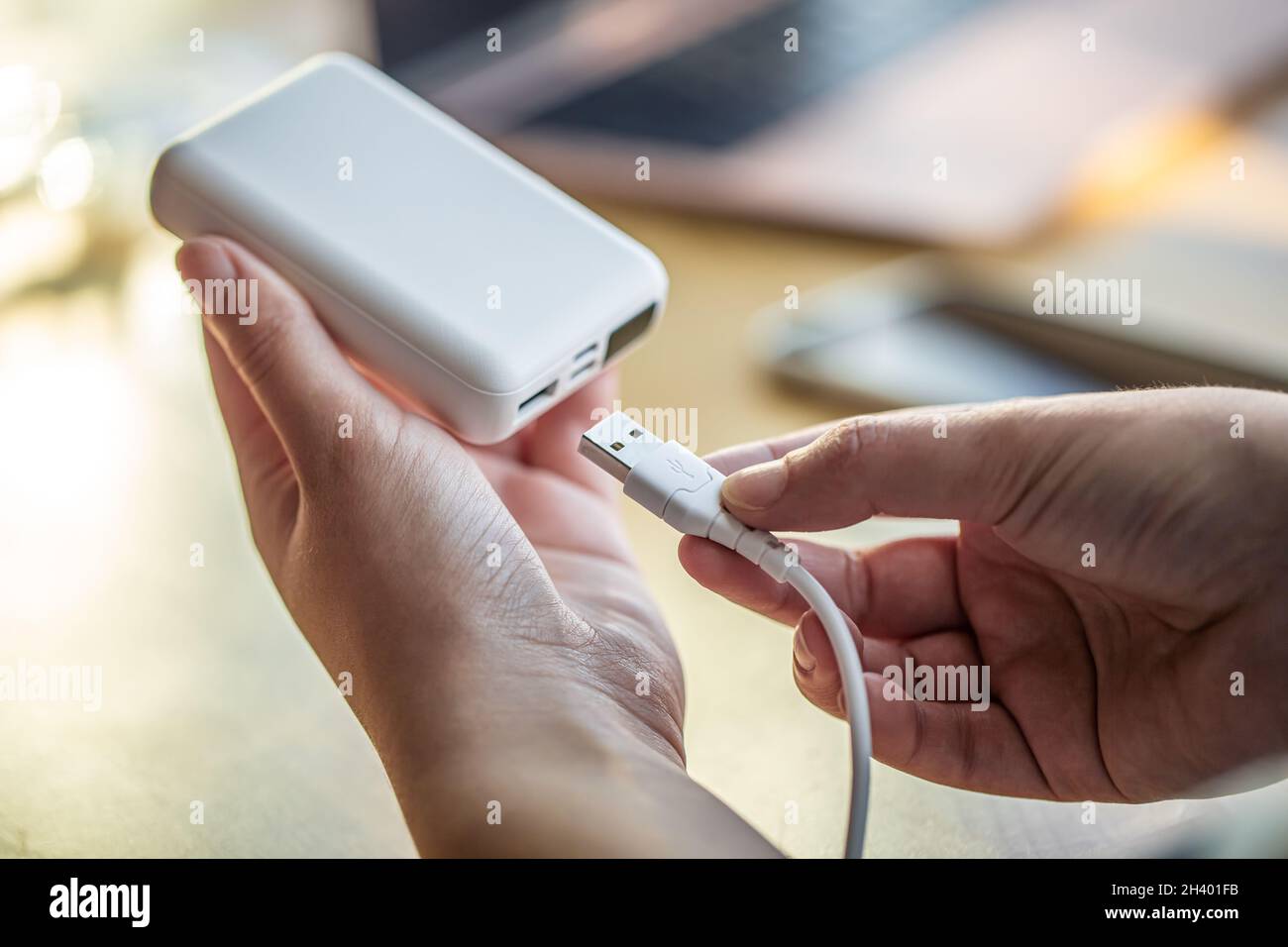 Woman's hand holding white USB cable and white power bank Stock Photo ...