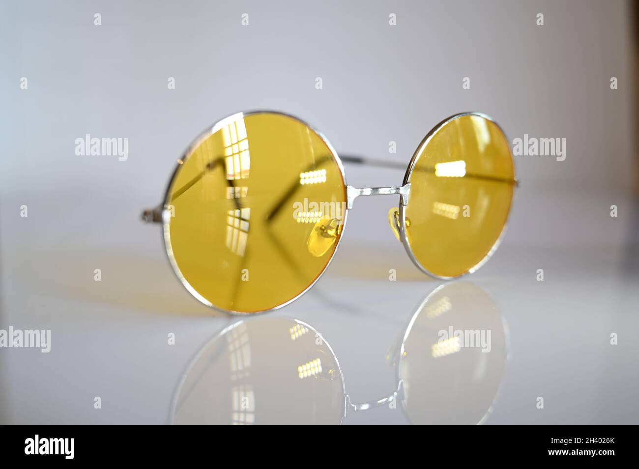 A close up of a yellow sunglass reflecting the light on a light ...