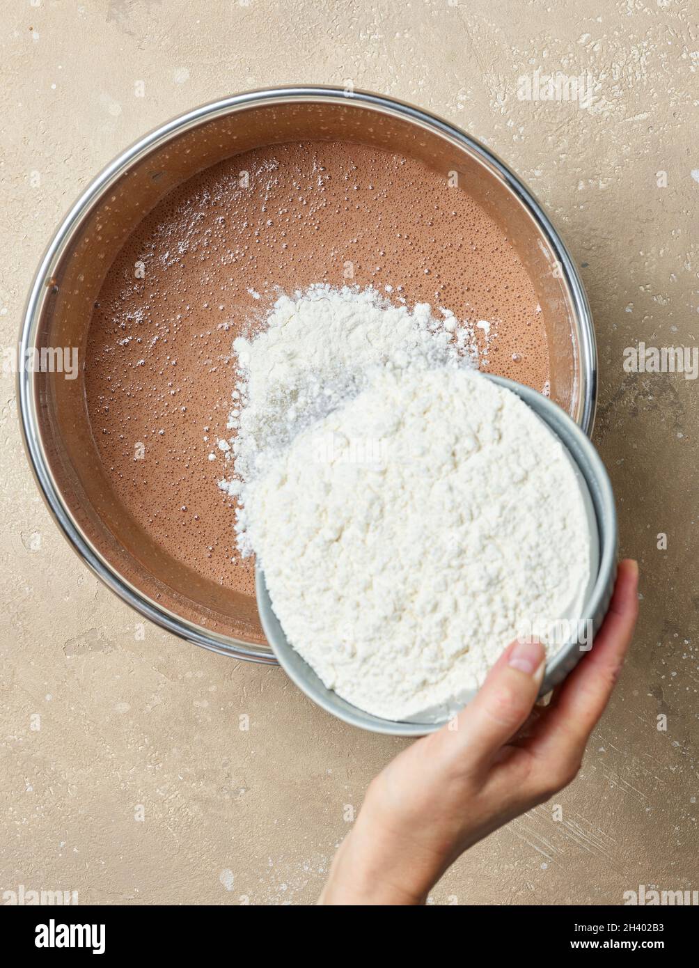 adding flour to the bowl of chocolate cake dough, top view Stock Photo ...