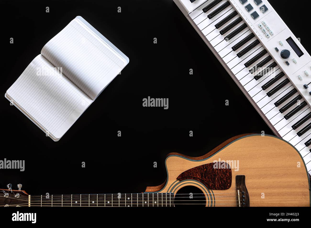 Music background with acoustic guitar, notepad and music keys on black ...