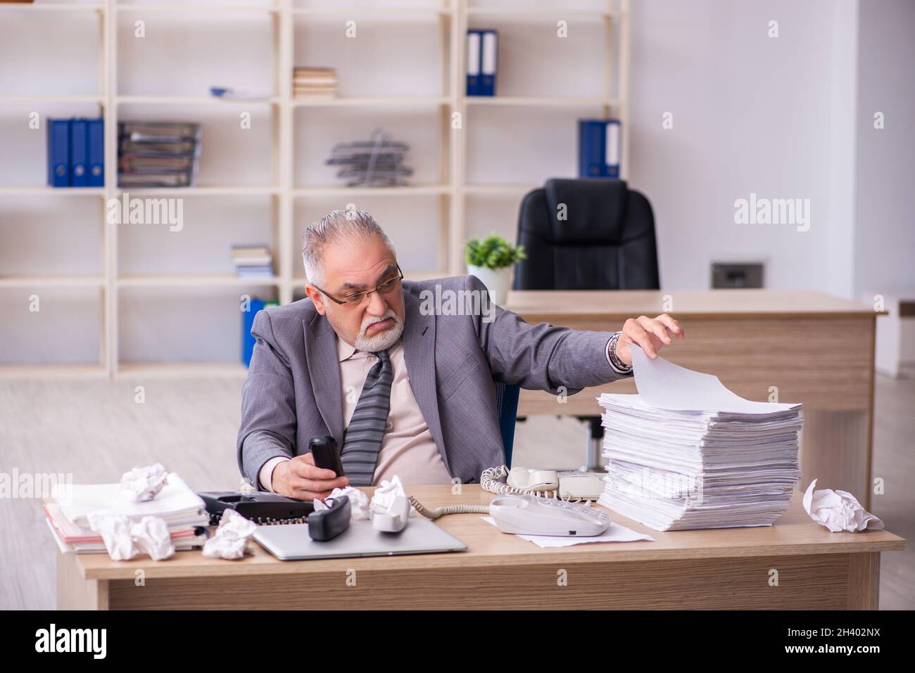 Old male employee working at workplace Stock Photo - Alamy