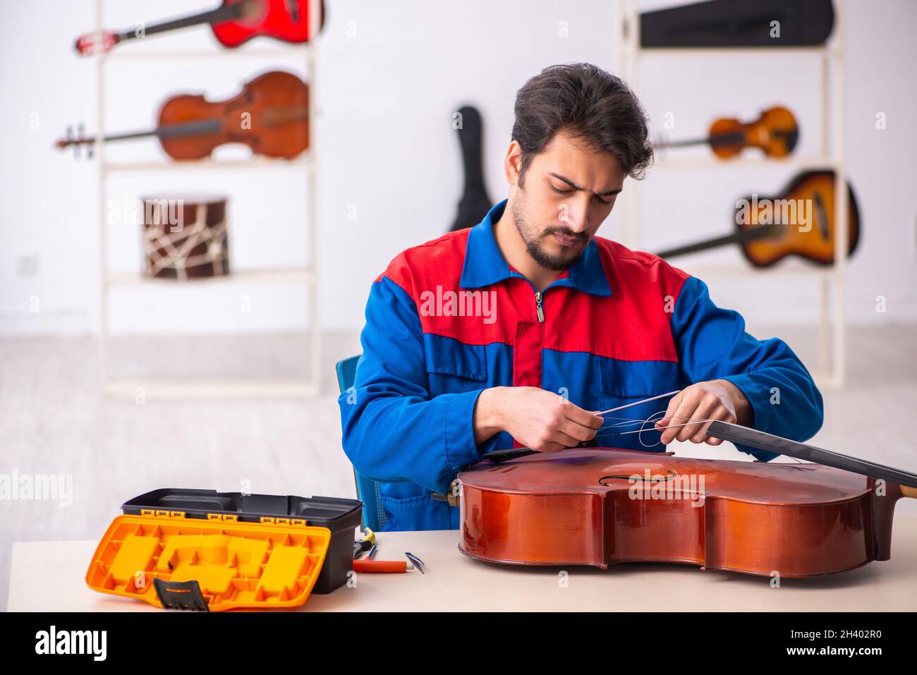 Young male repairman repairing musical instruments at workplace Stock ...