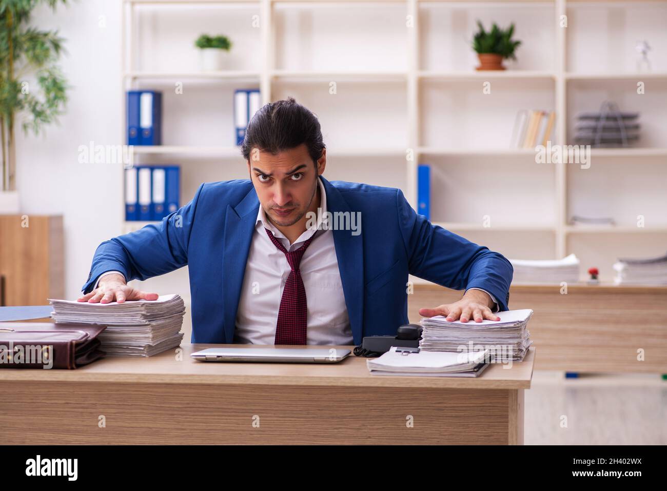 Extremely tired young male employee in the office Stock Photo - Alamy