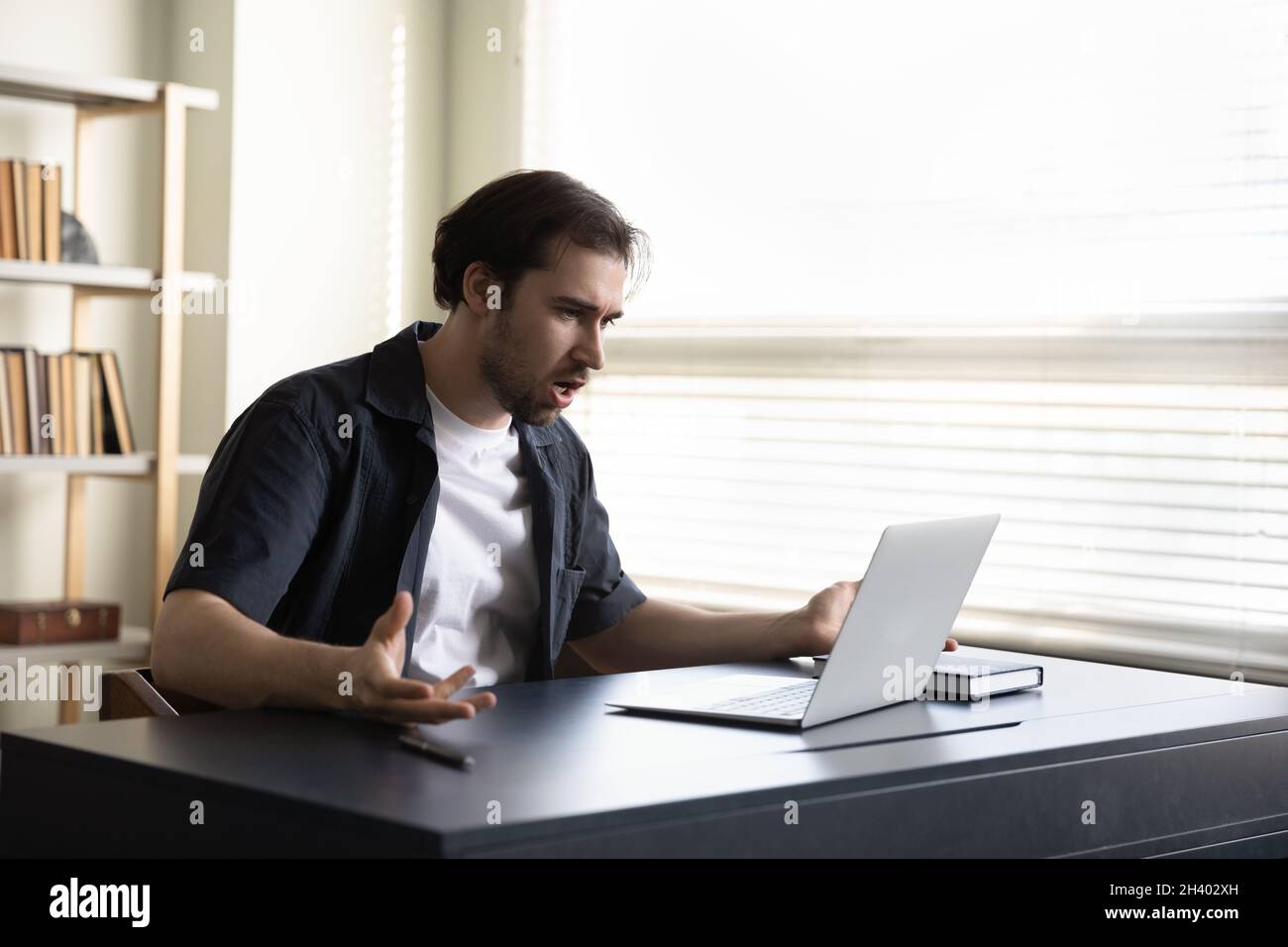 Confused angry young man working on computer Stock Photo - Alamy