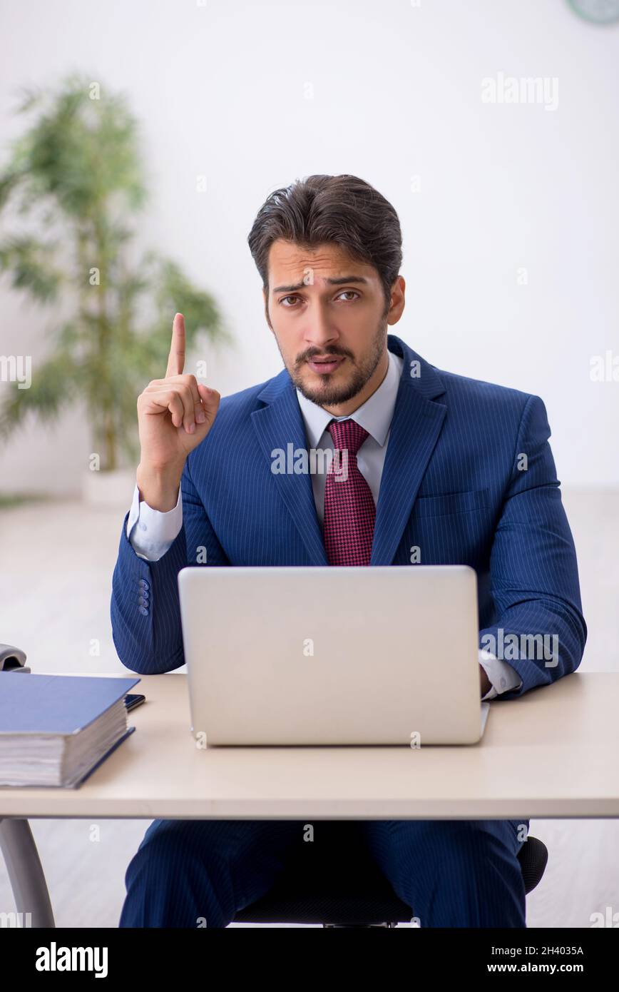 Young male employee working at workplace Stock Photo - Alamy