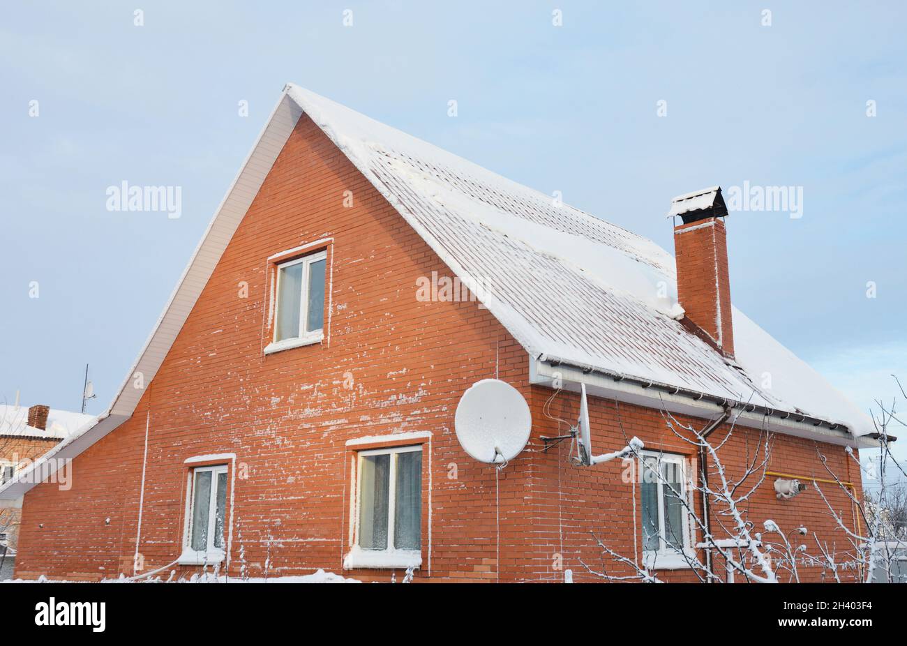 Brick house with a steep roof covered with snow Stock Photo - Alamy