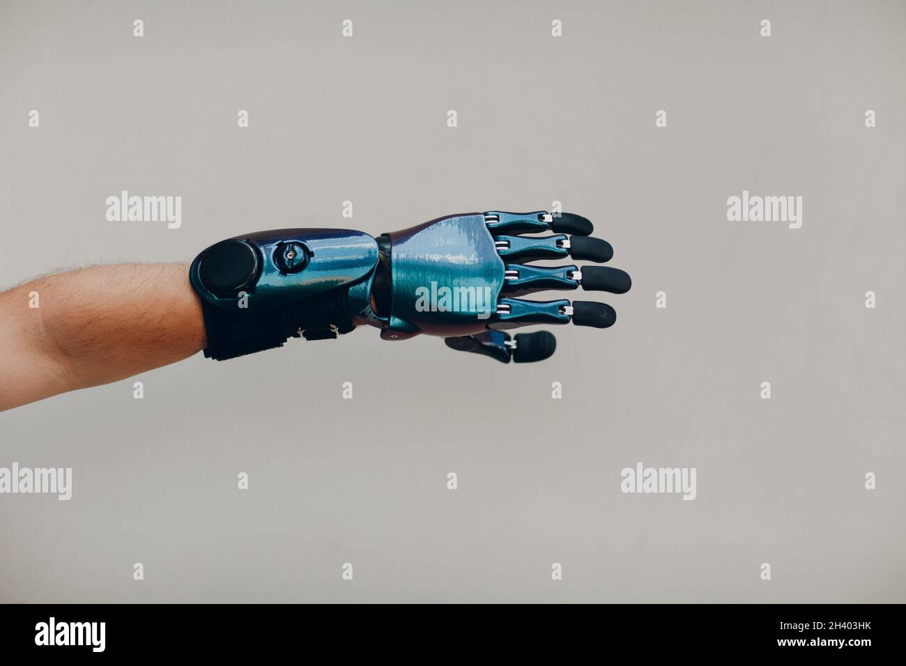 Disabled man with artificial prosthetic hand close up hand against gray ...