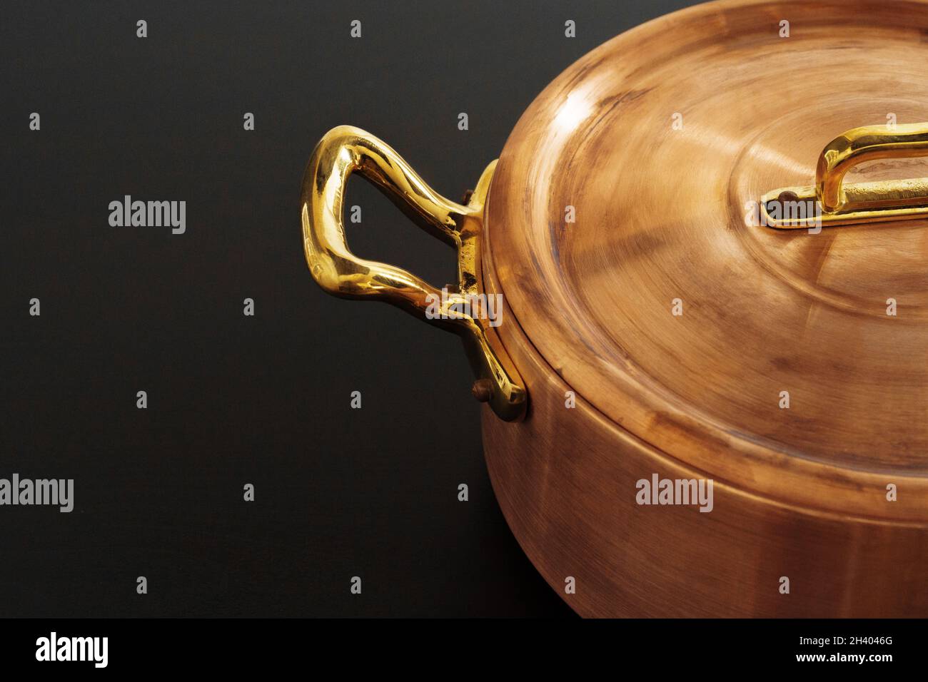 Shiny vintage copper cookware over dark background Stock Photo - Alamy