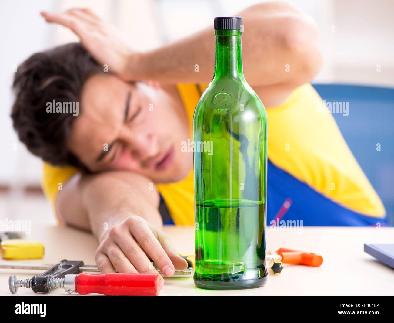 Drunk engineer working in the workshop Stock Photo - Alamy