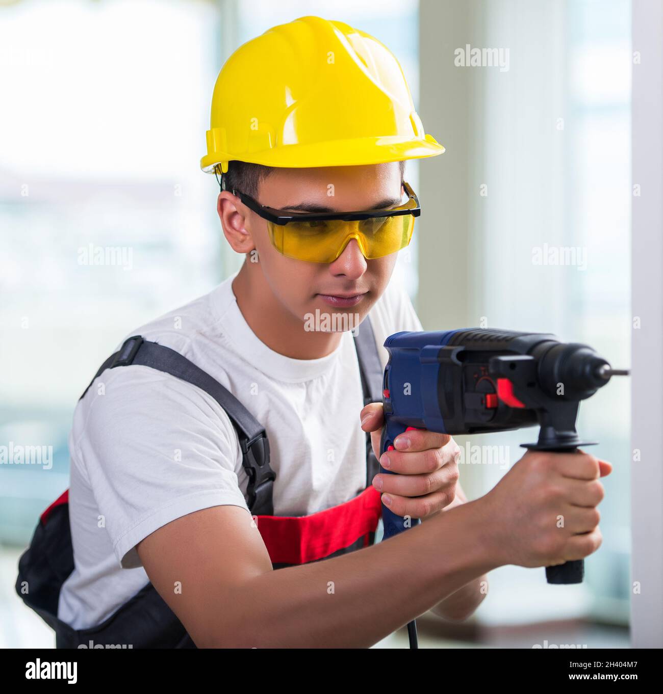 Man drilling the wall with drill perforator Stock Photo - Alamy