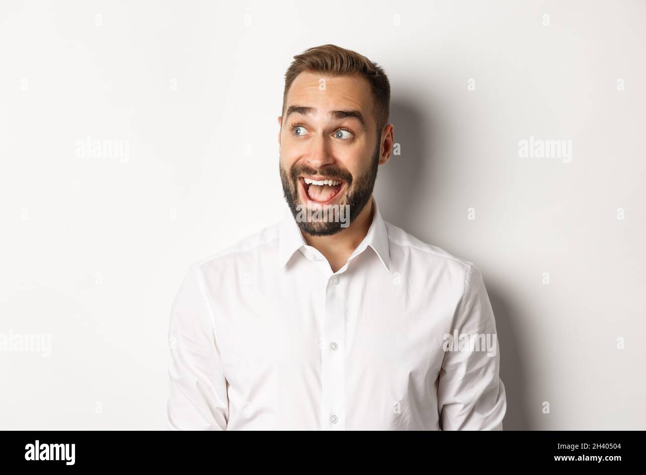 Close-up of happy and surprised man looking left with excitement, white ...