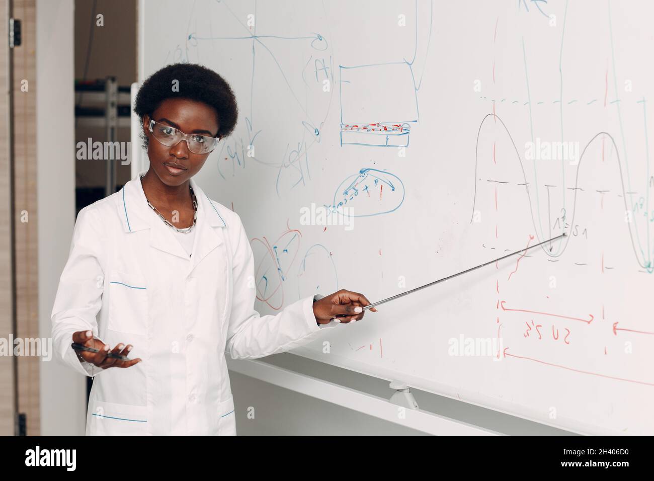 African American woman math teacher stands at blackboard with pointer ...