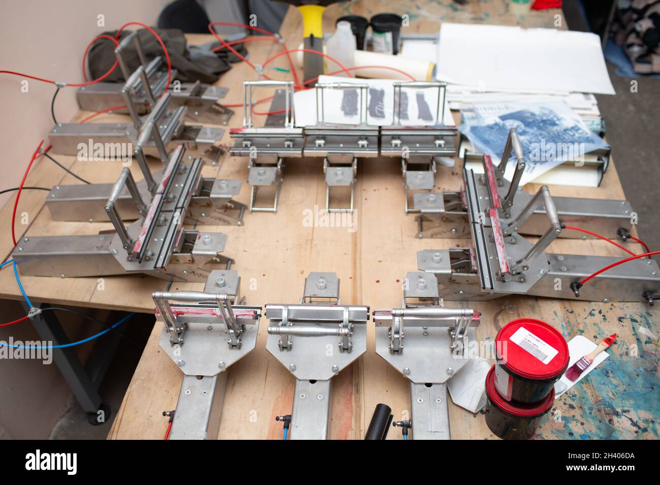 Serigraphy silk screen print process at clothes factory. Tensioner ...