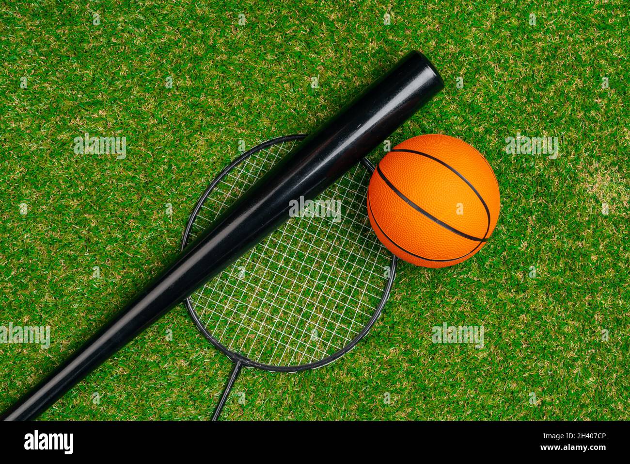 Baseball bat and badminton racket on grass, top view Stock Photo - Alamy