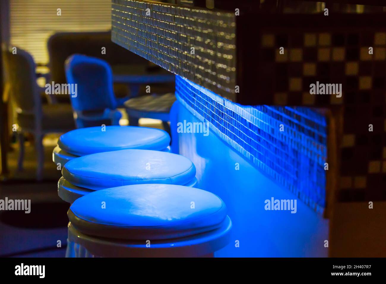 Empty stools along bar Illuminated in blue light Stock Photo - Alamy