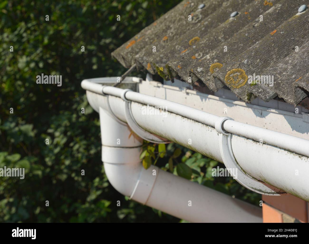 Roof gutter. House asbestos roof with plastic roof gutter pipe. House ...