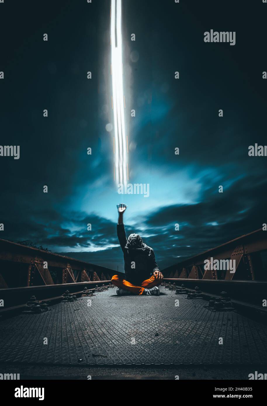 A man on the bridge sending magical power to heaven at night Stock ...