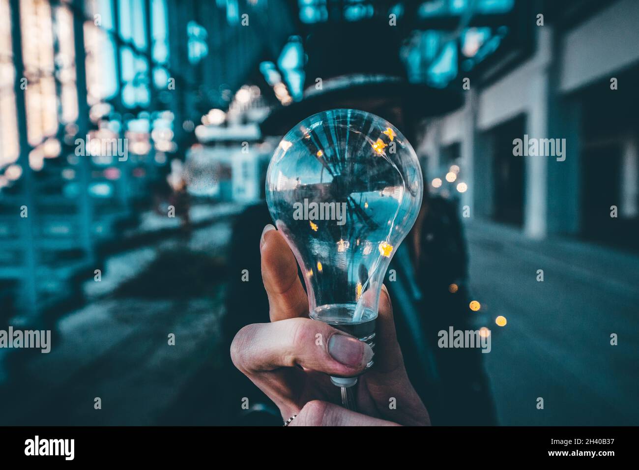 A selective of a light bulb in a hand on the background of a female ...