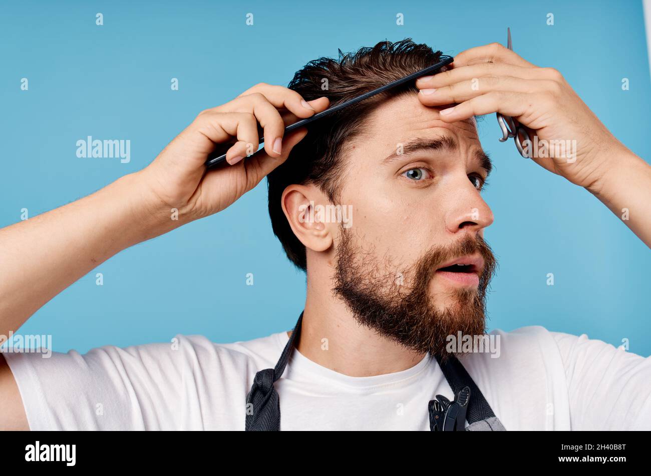 male hairdresser barbershop haircut blue background Stock Photo - Alamy
