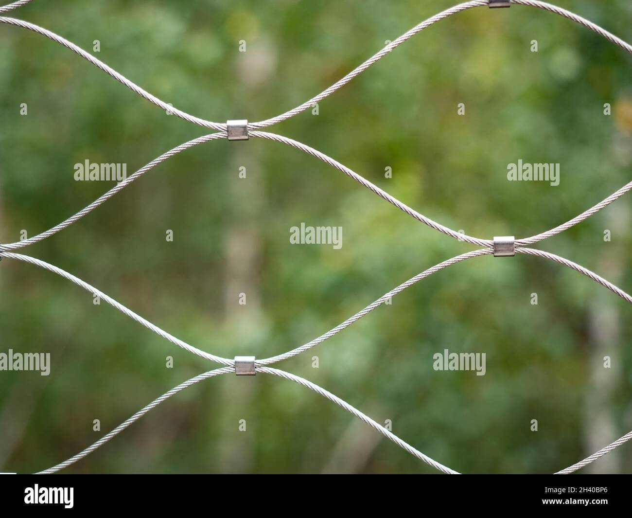 Modern chrome steel wire mesh fence with pressed joints on natural ...