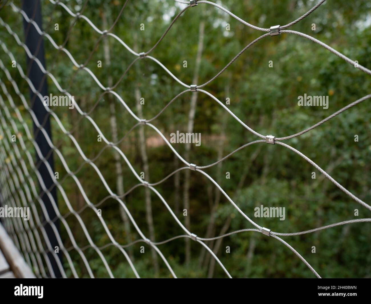 Modern chrome steel wire mesh fence with pressed joints on natural ...