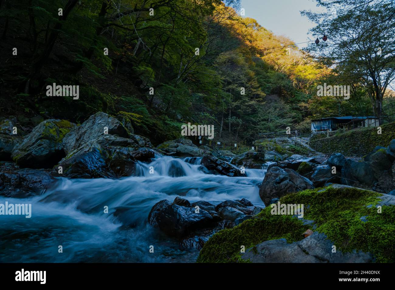 Slow shutter image of the cascading Tama river flowing over boulders in ...