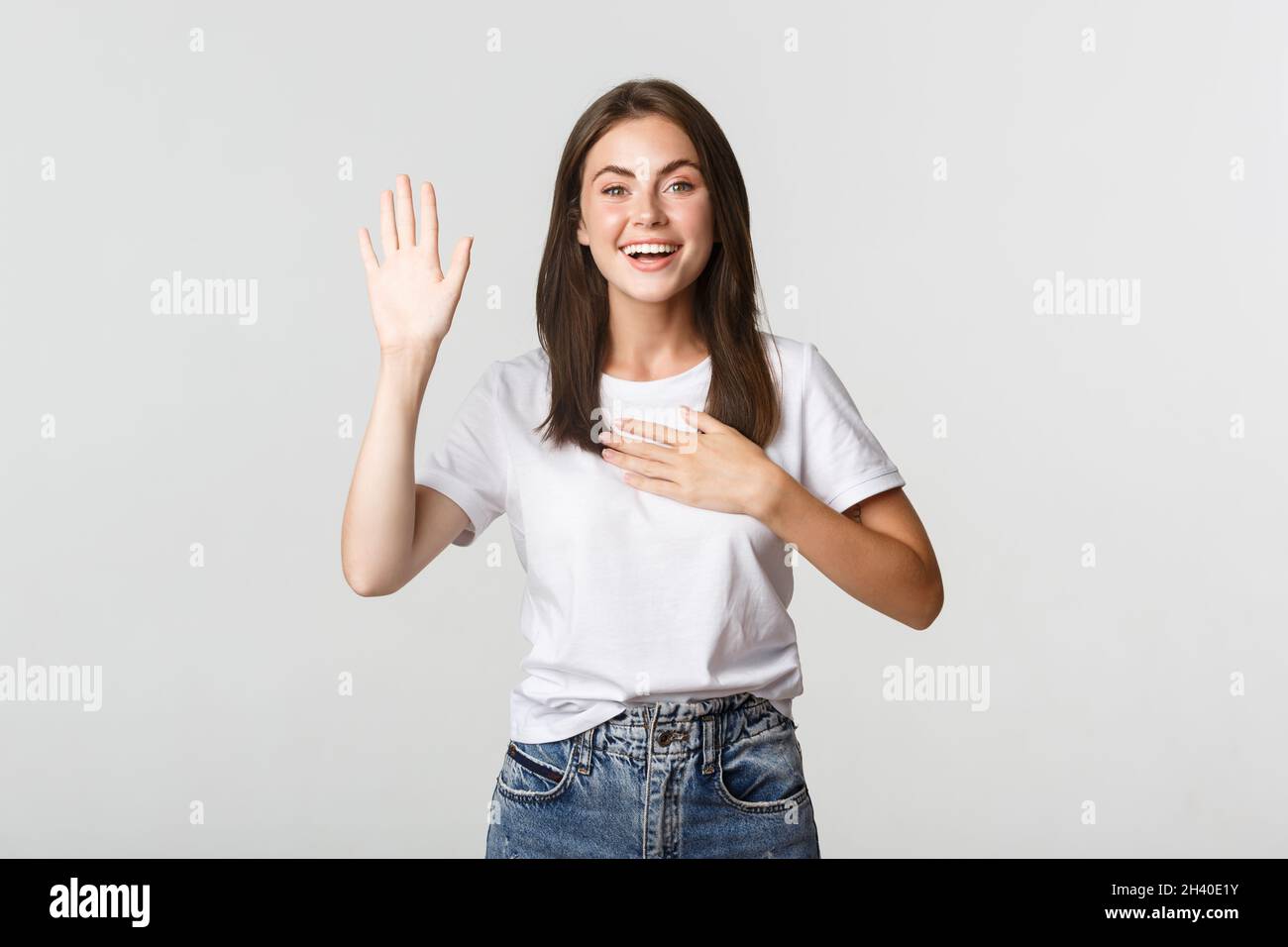 Honest smiling cute girl telling truth, raising hand to make promise ...