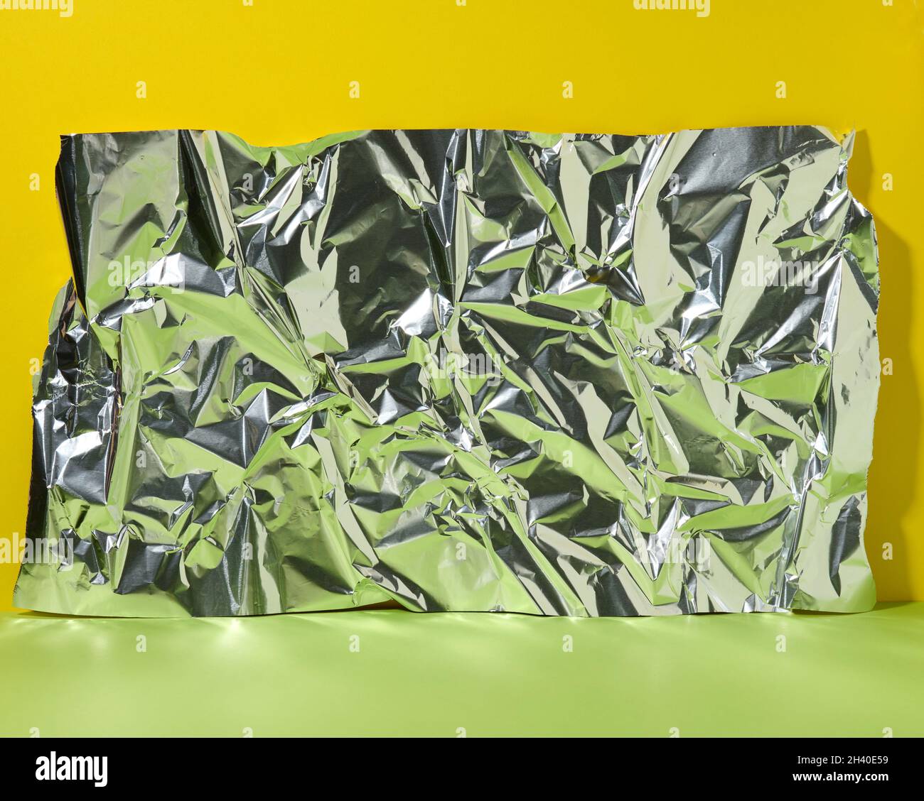Abstract background for product demonstration, crumpled foil with green ...