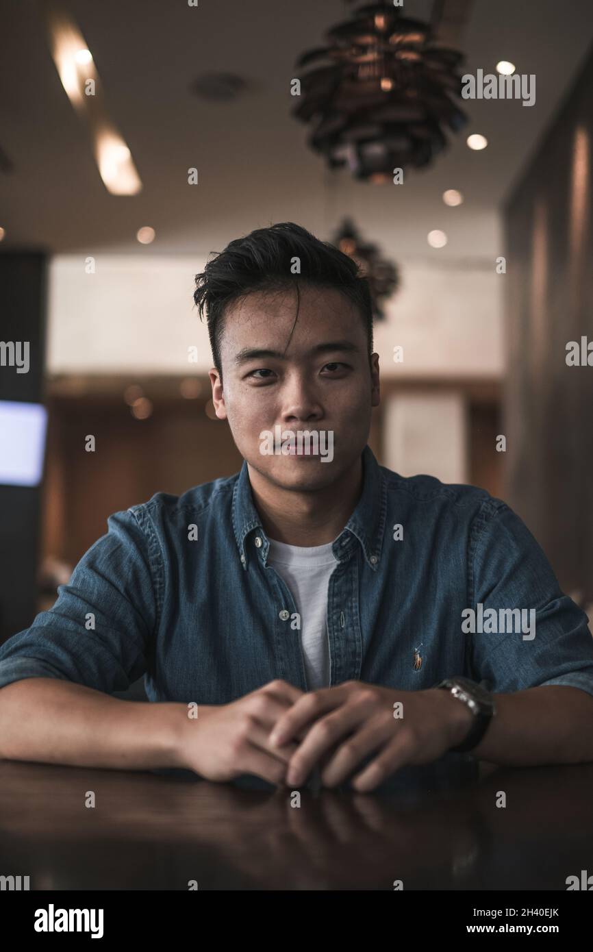 Asian young handsome man sitting in coffee shop and smiling. Chinese ...