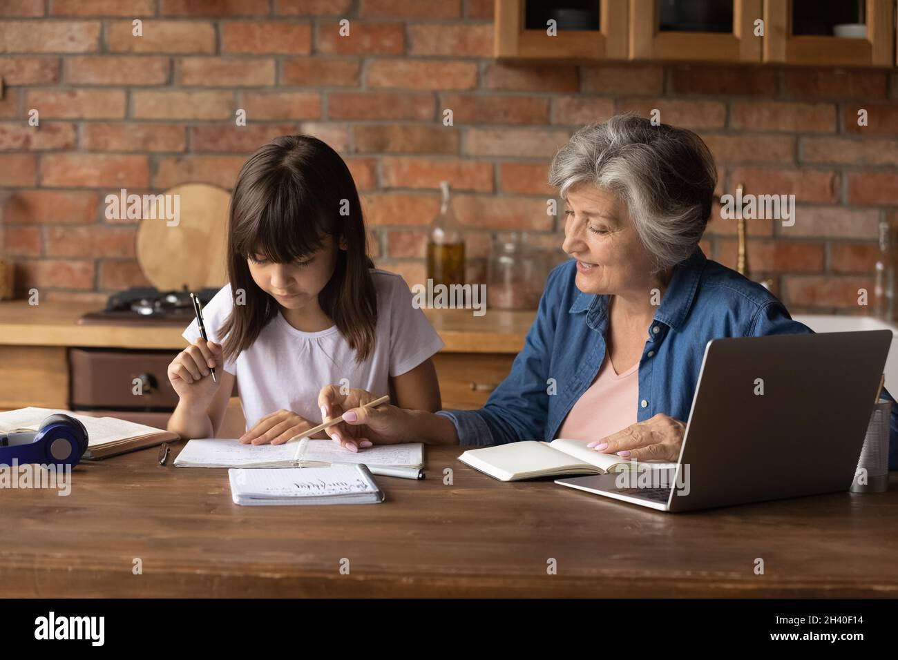 Senior grandmother helping schoolkid granddaughter to do homework Stock ...