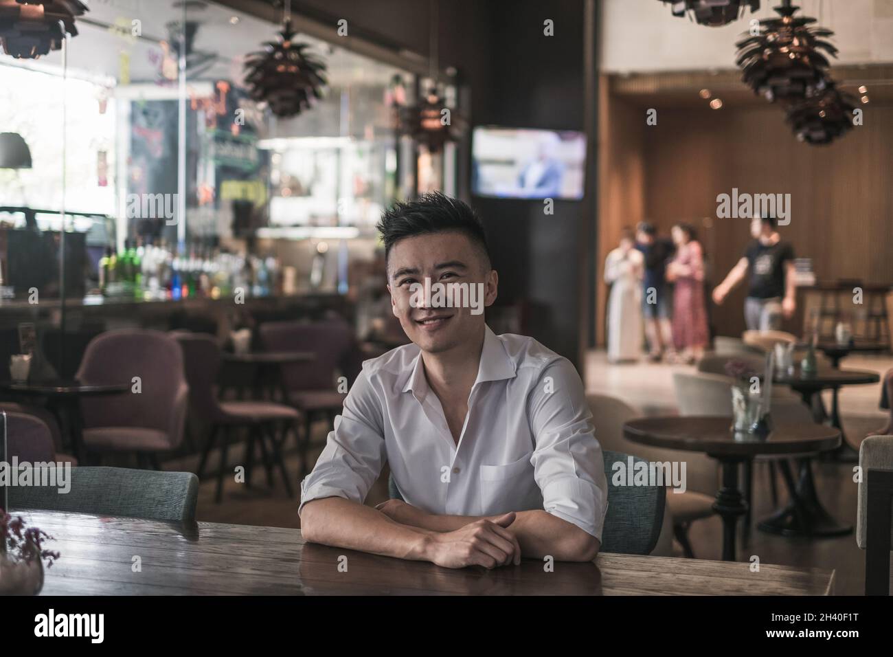 Asian young handsome man sitting in coffee shop and smiling. Chinese ...