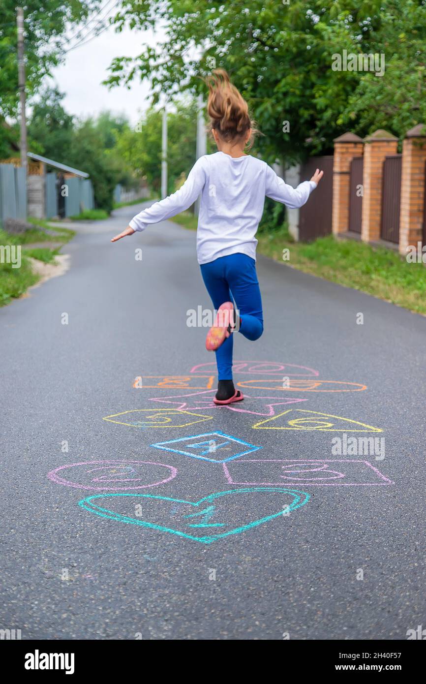 Child jumping classics on the street. Selective focus. Kid Stock Photo ...