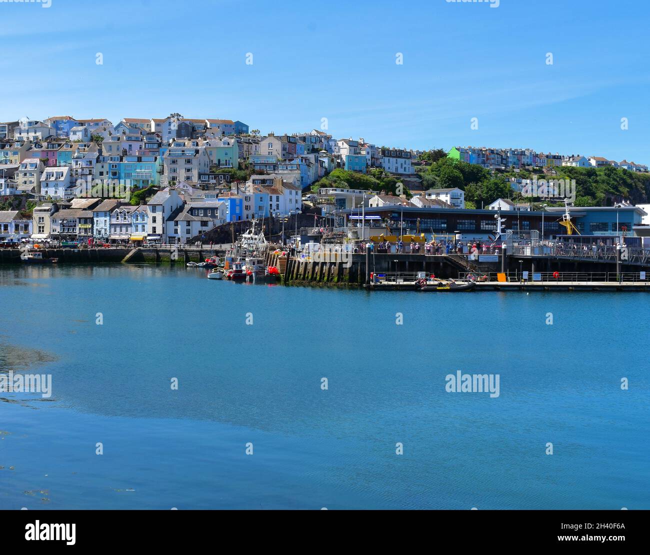 traditional scene of Brixham Harbour with fishing boats tied up against ...