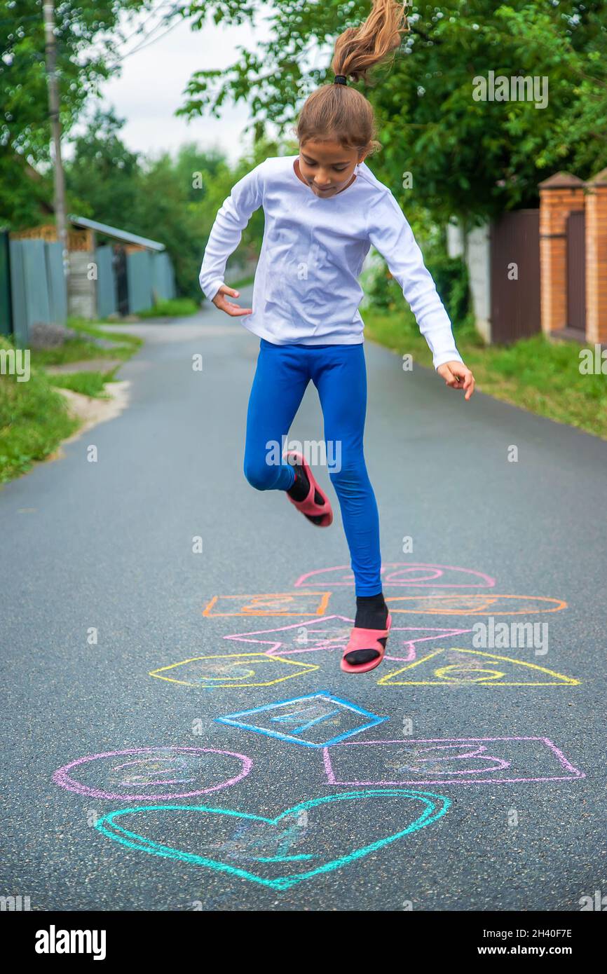 Child jumping classics on the street. Selective focus. Kid Stock Photo ...
