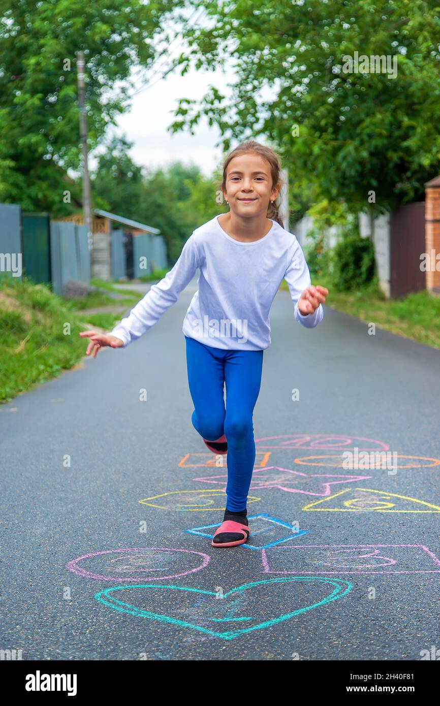 Child jumping classics on the street. Selective focus. Kid Stock Photo ...