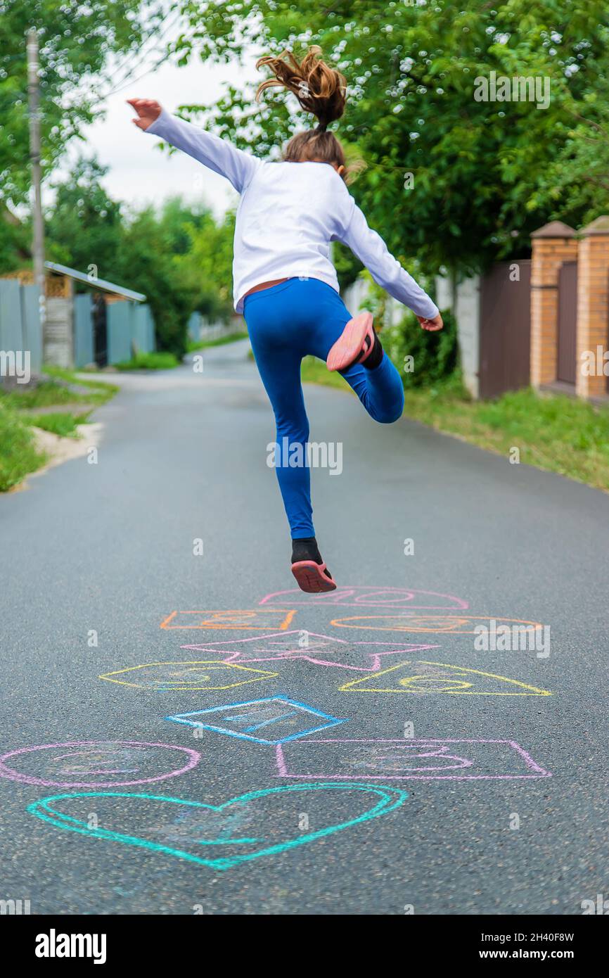 Child jumping classics on the street. Selective focus. Kid Stock Photo ...