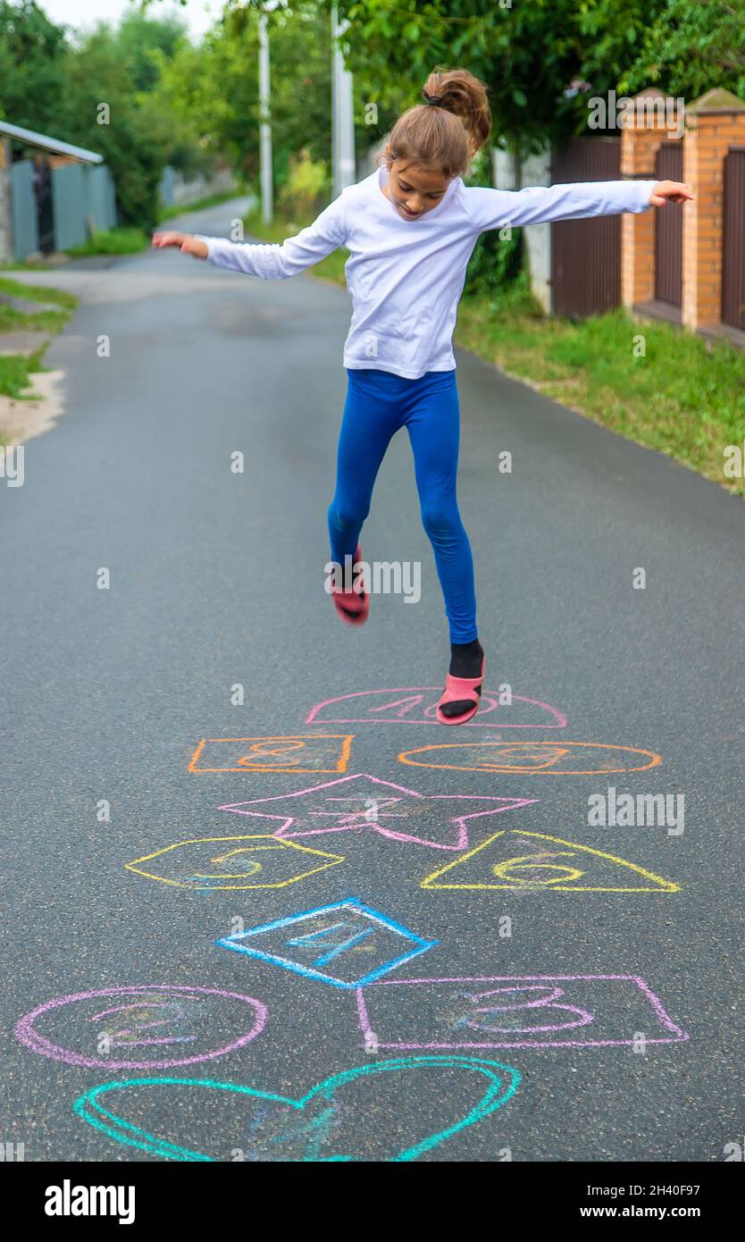 Child jumping classics on the street. Selective focus. Kid Stock Photo ...
