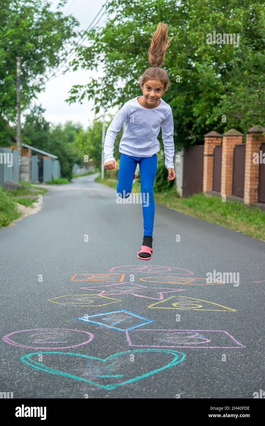 Child jumping classics on the street. Selective focus. Kid Stock Photo ...