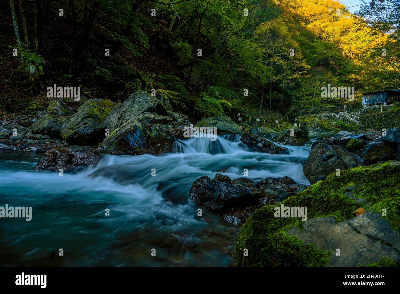 Slow shutter image of the cascading Tama river flowing over boulders in ...