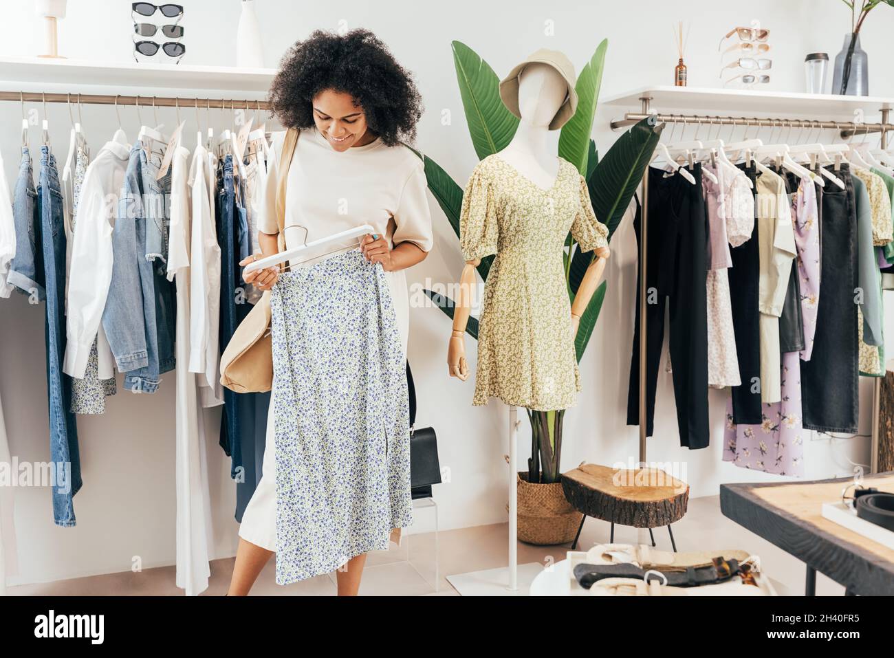 Stylish woman choosing dress in a boutique Stock Photo - Alamy